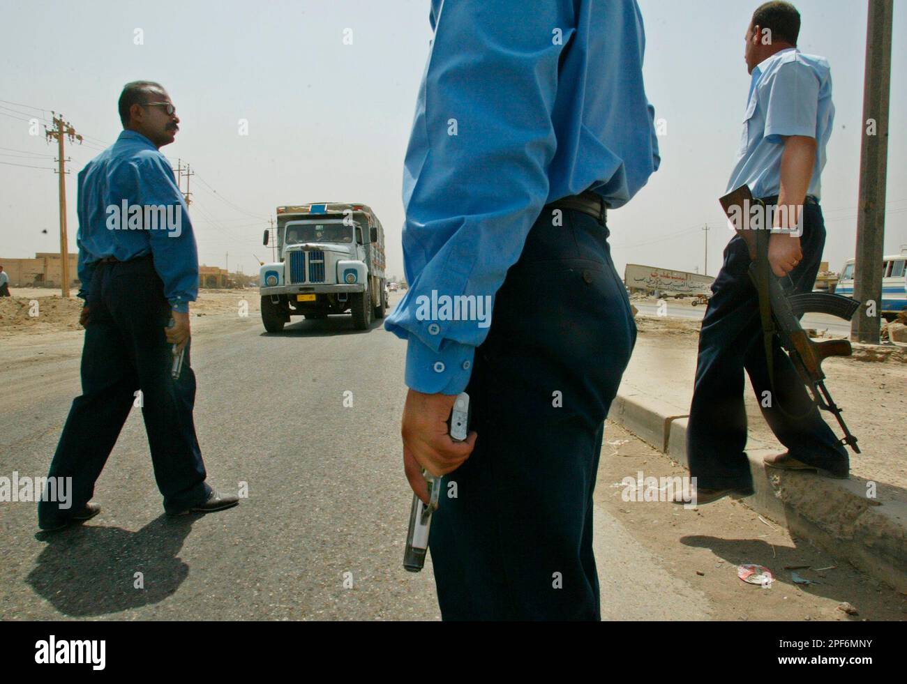 Iraqi police stand guard at a checkpoint on the outskirts of Baghdad ...