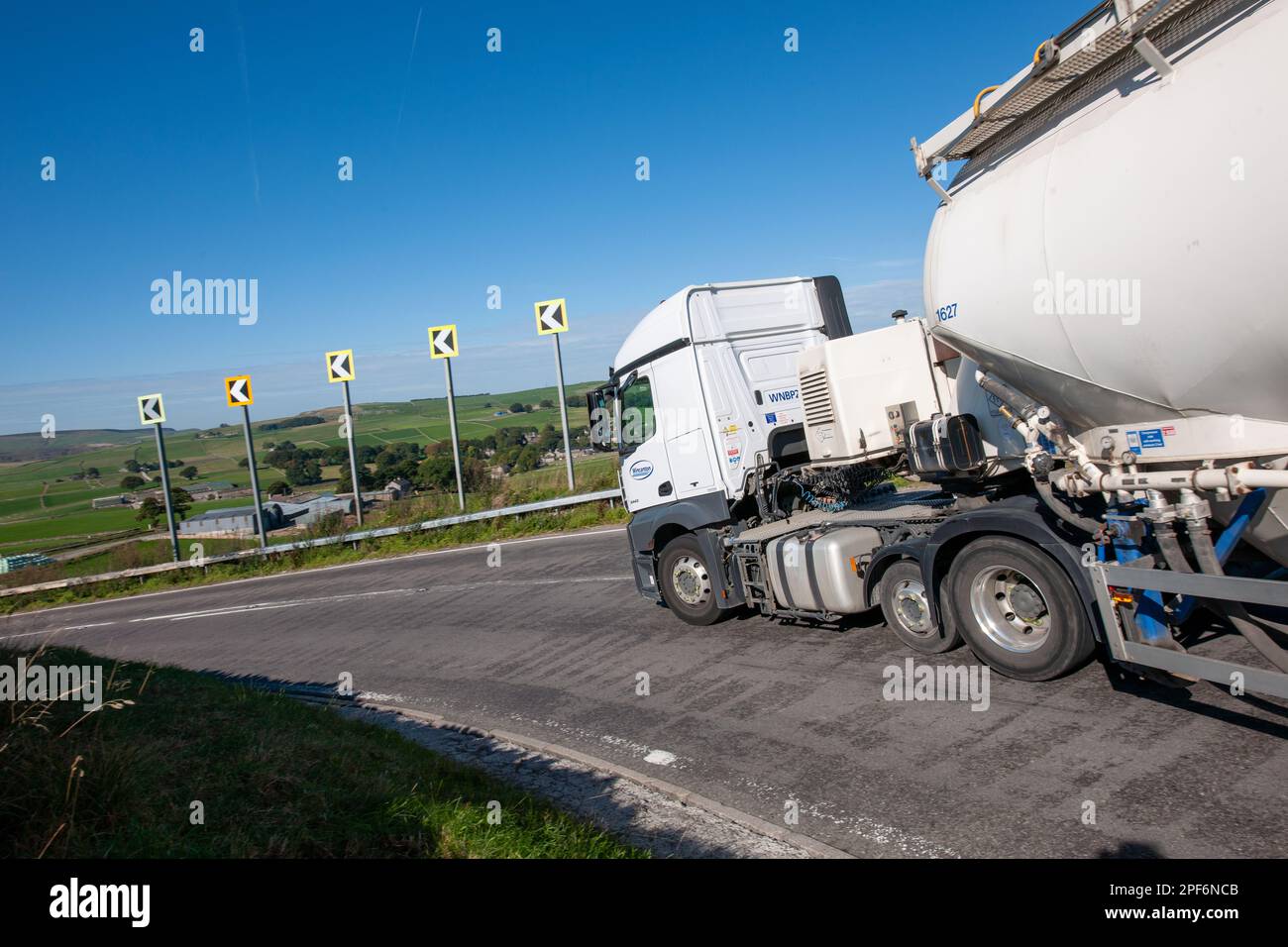 Truck pulling a dry powder tanker negotiating a tight left hand bend on ...