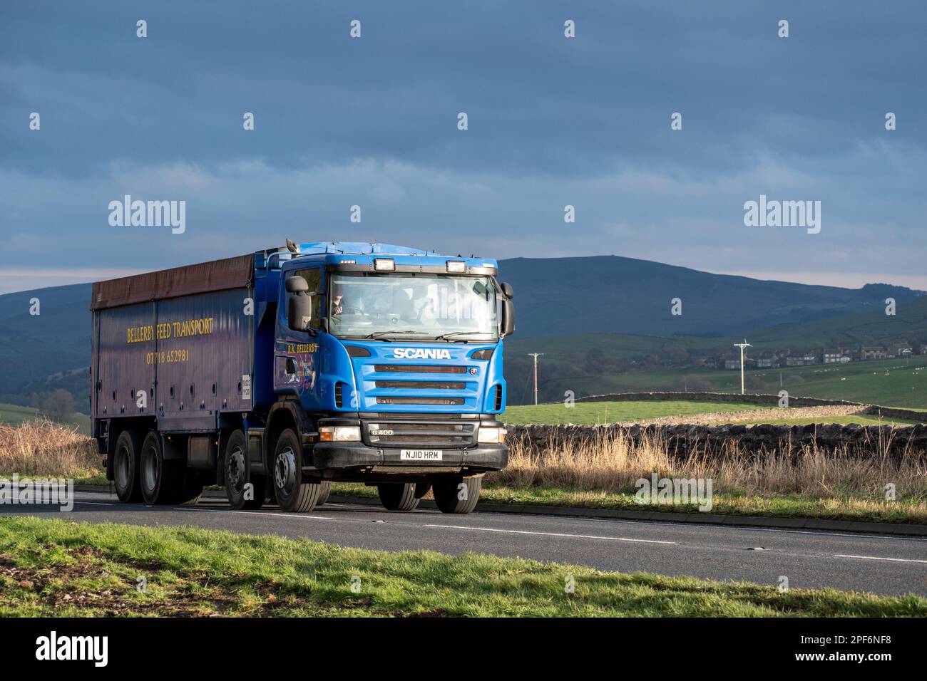 Scania eight-wheel bulk tipper driving on a country B-road in Yorkshire ...