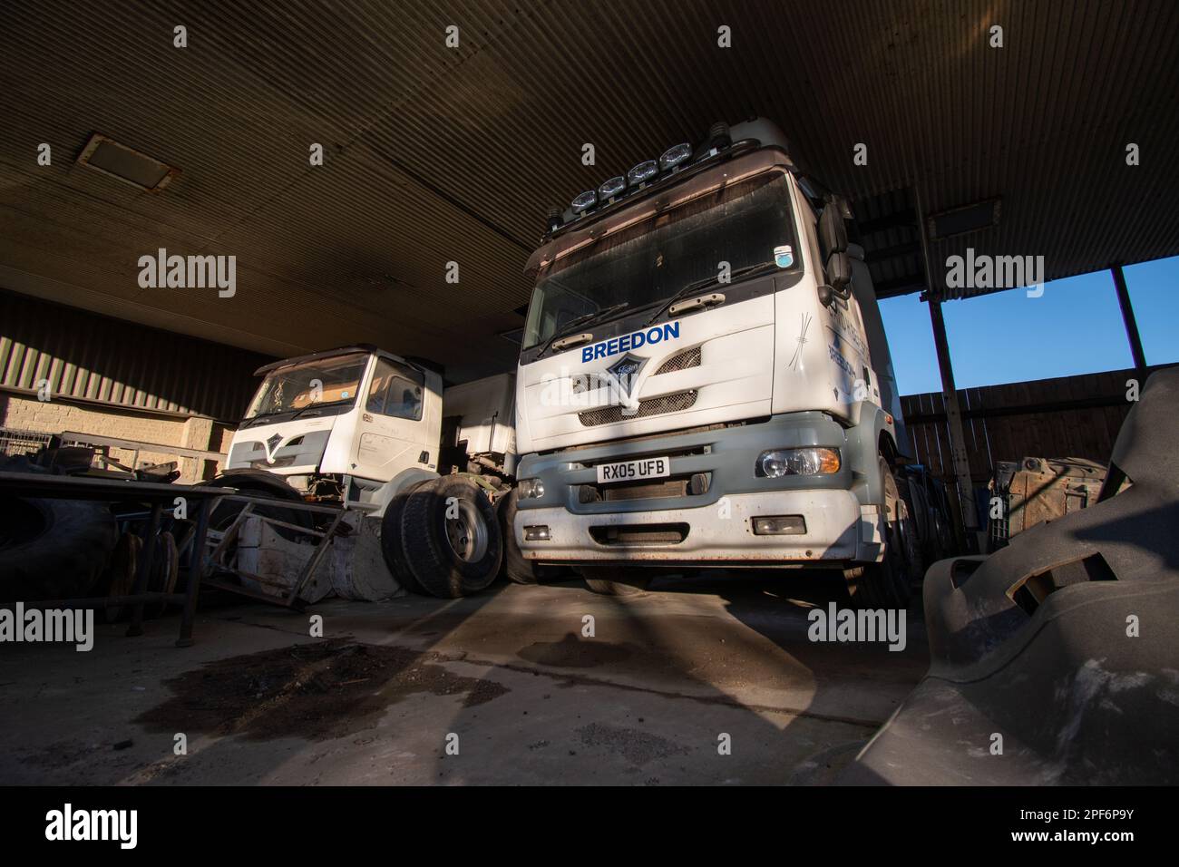 Disused Foden tipper trucks stored in a garage at a transport yard ...