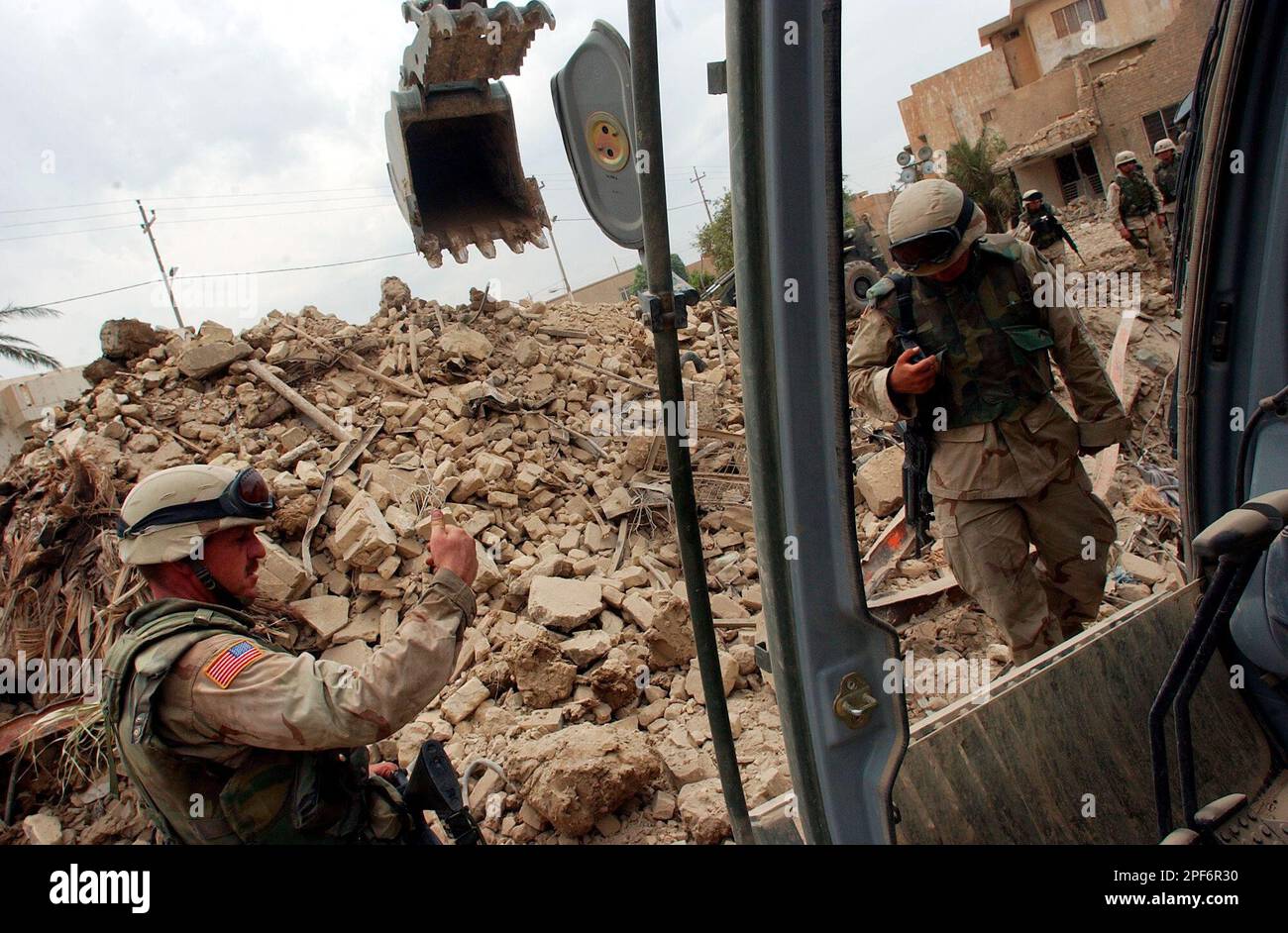 U.S. soldiers from an engineers unit take a looks at a 15-foot crater ...