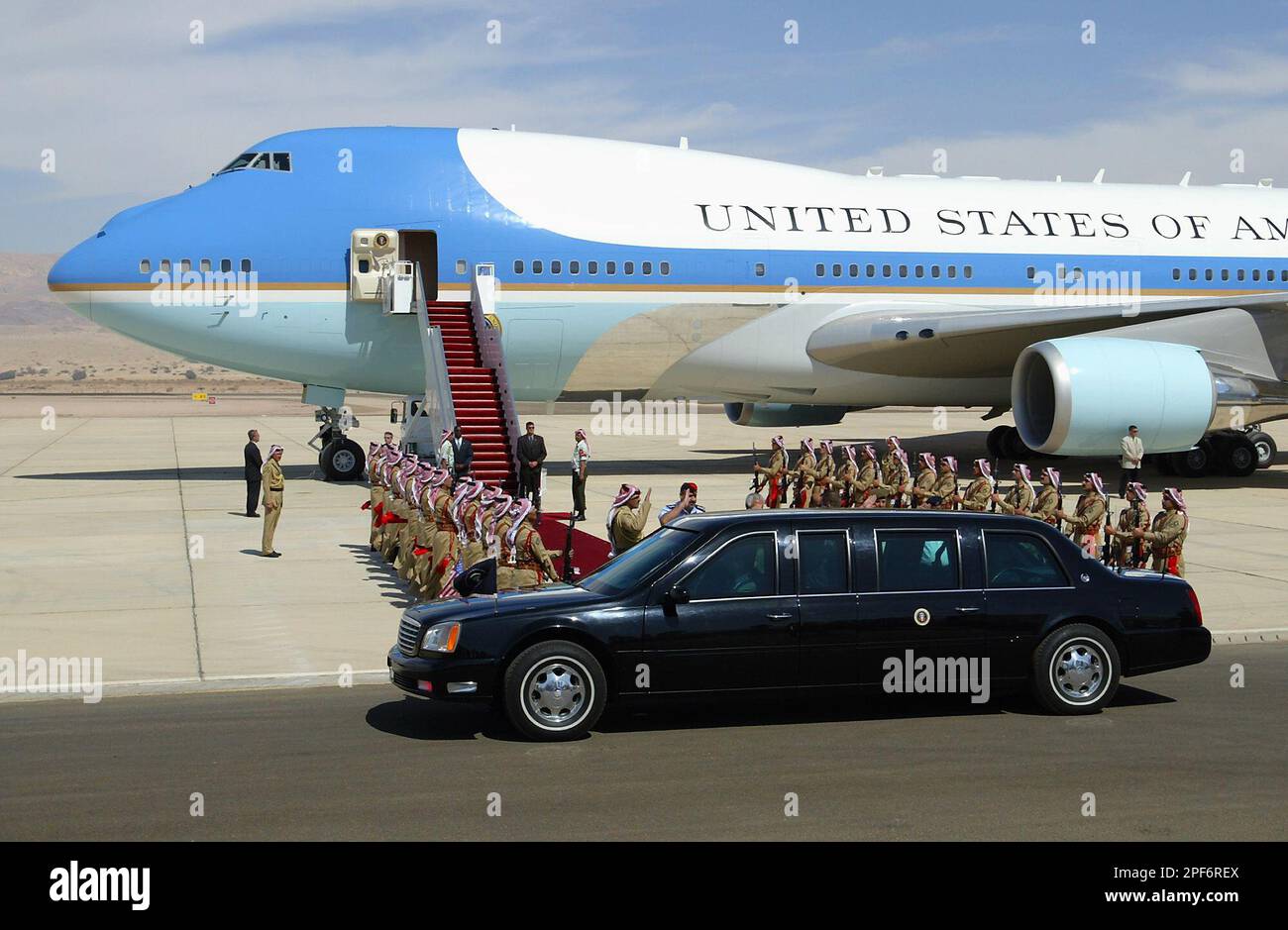 A black bulletproof limousine with U.S. President George W. Bush passes ...