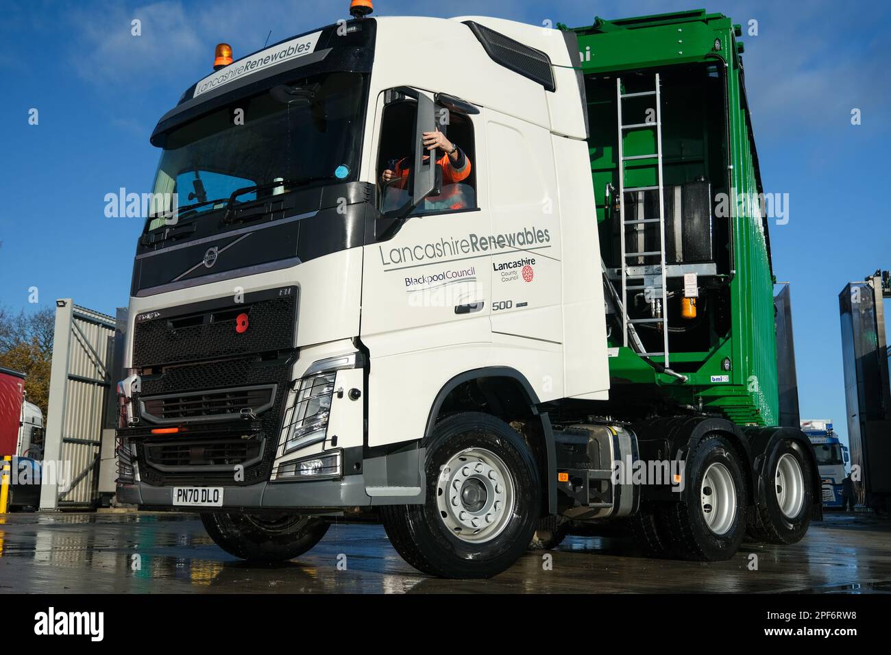 Volvo truck pulling a bulk tipper recycling trailer pulls out of a ...