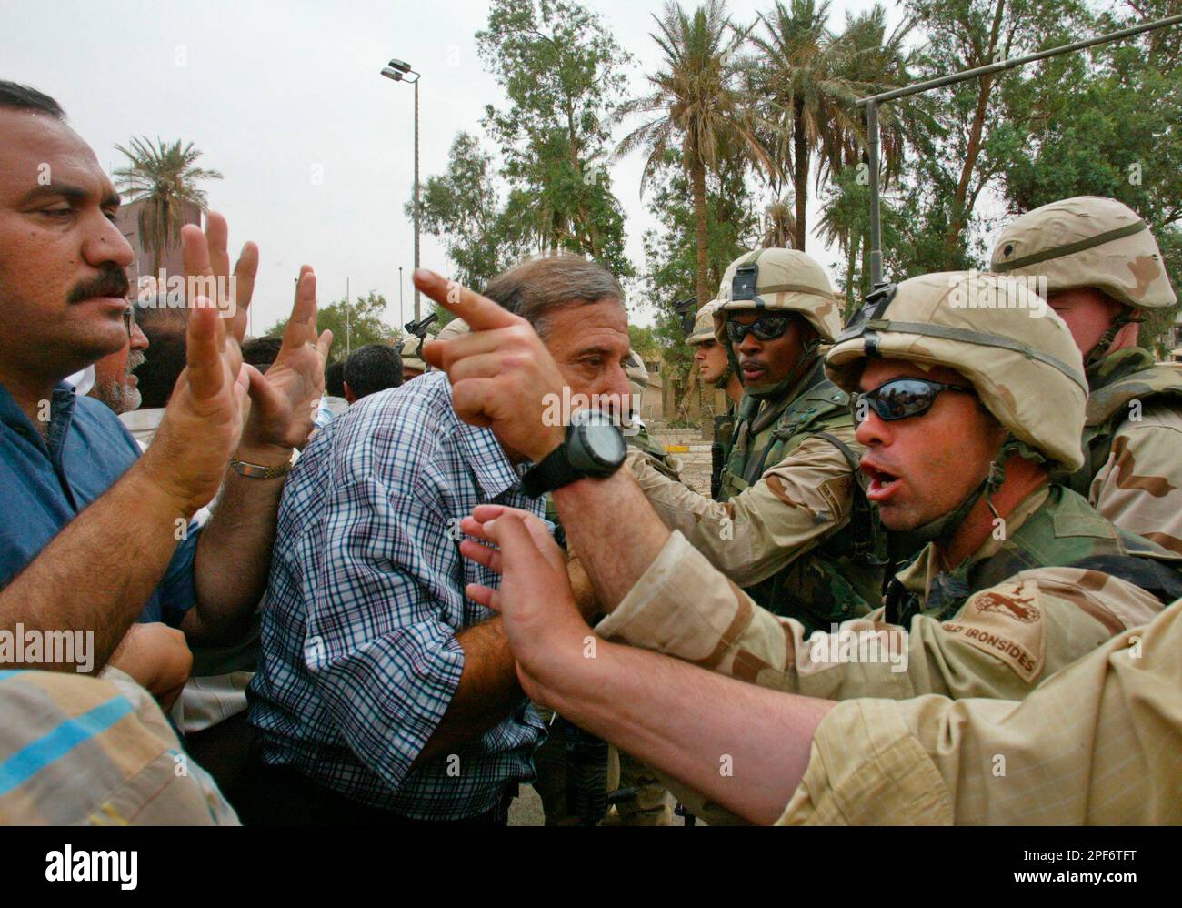 U.S. soldiers argue with former Iraqi soldiers demanding payment of ...