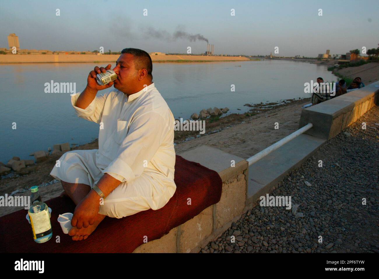 A local resident enjoys alcoholic drinks on the bank of river Tigris in ...