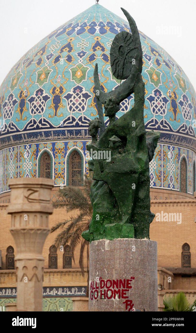 A statue featuring a central figure beneath a crescent moon stands atop ...
