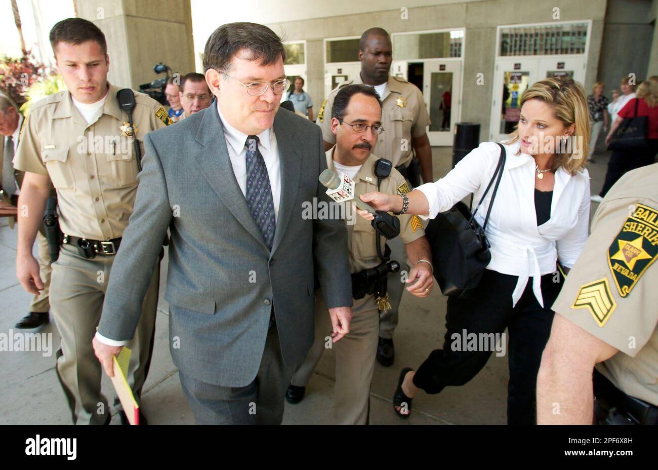Former Catholic priest Mark Roberts, surrounded by bailiffs, leaves the ...