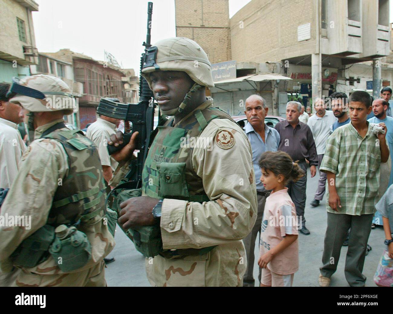 US soldiers patrol in a busy street in an old part of Baghdad, Iraq ...