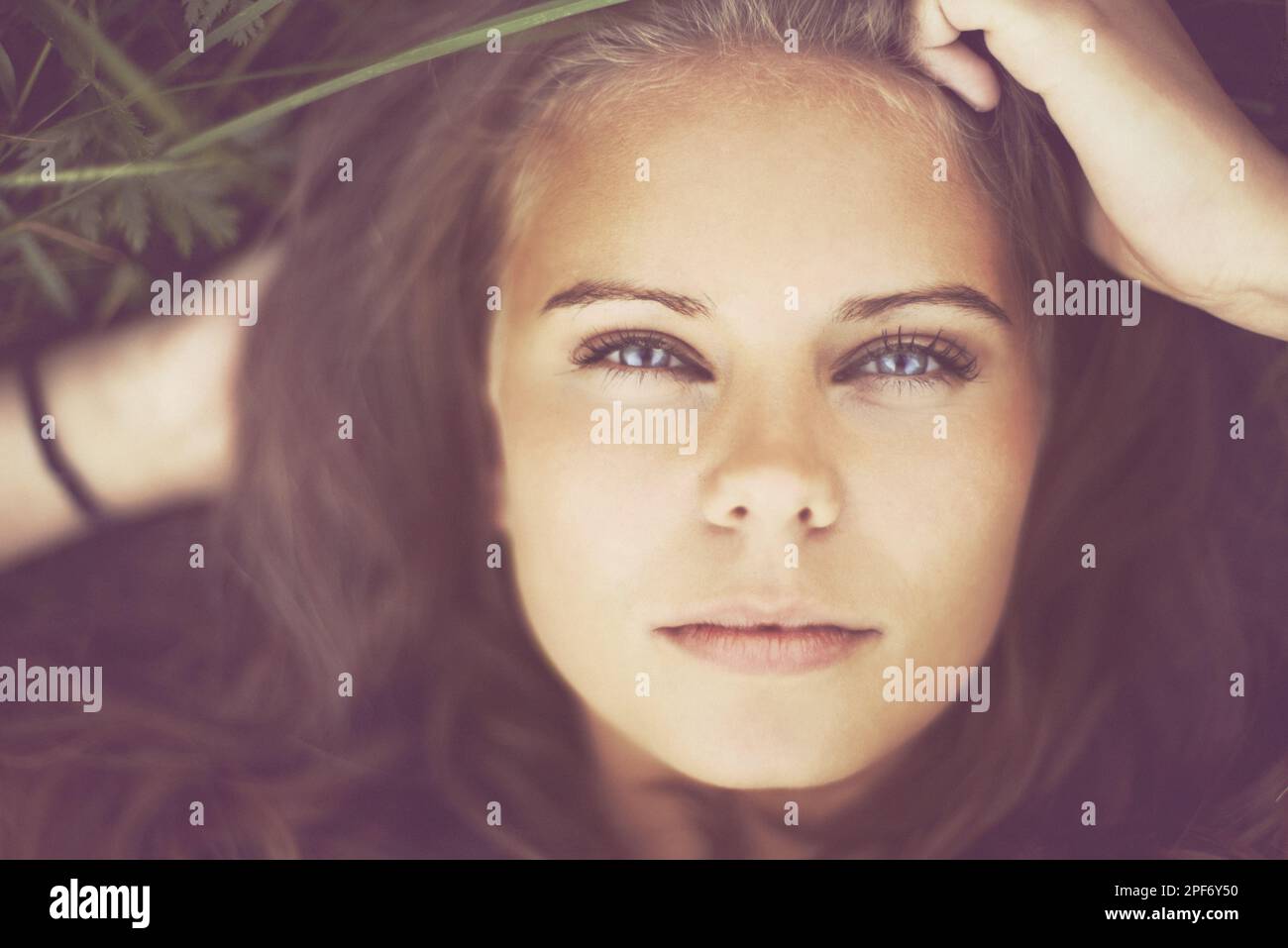 In touch with nature. Portrait of a gorgeous woman lying in the grass ...