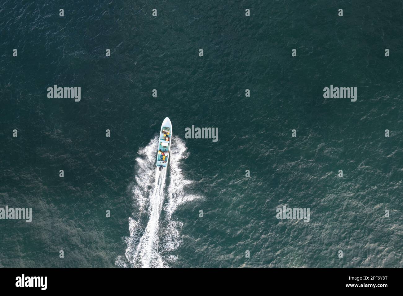 Moving fishing boat on green sea water above top view Stock Photo - Alamy