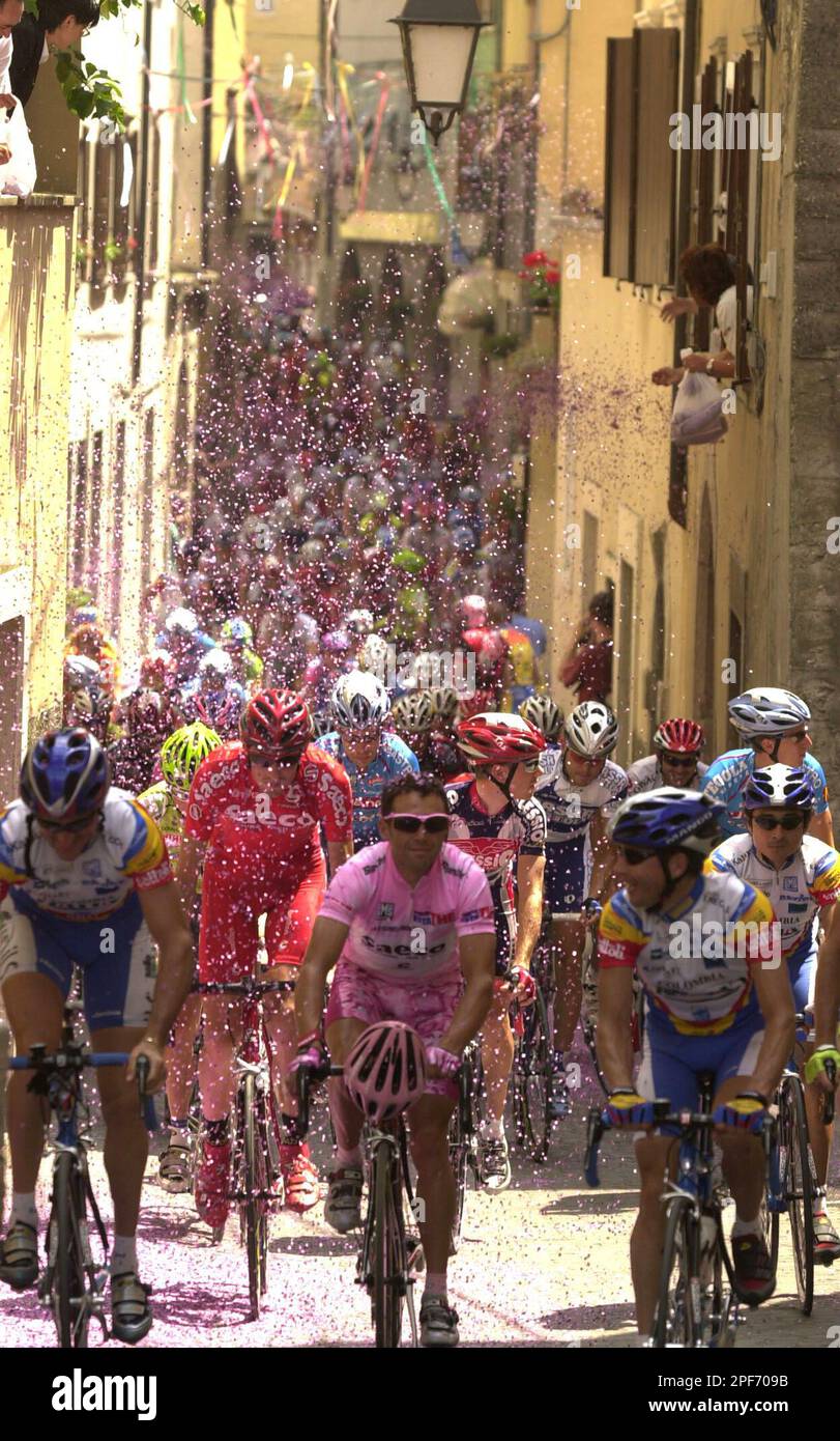 Cyclists ride their way through confetti at the start of the16th stage ...