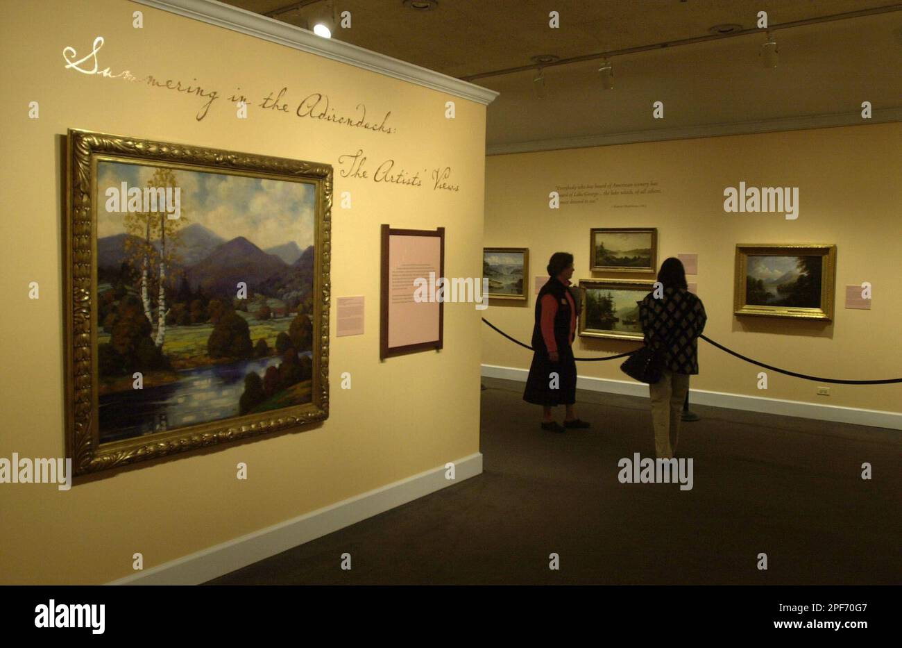 Museum visitors view paintings that are part of an exhibition titled ...