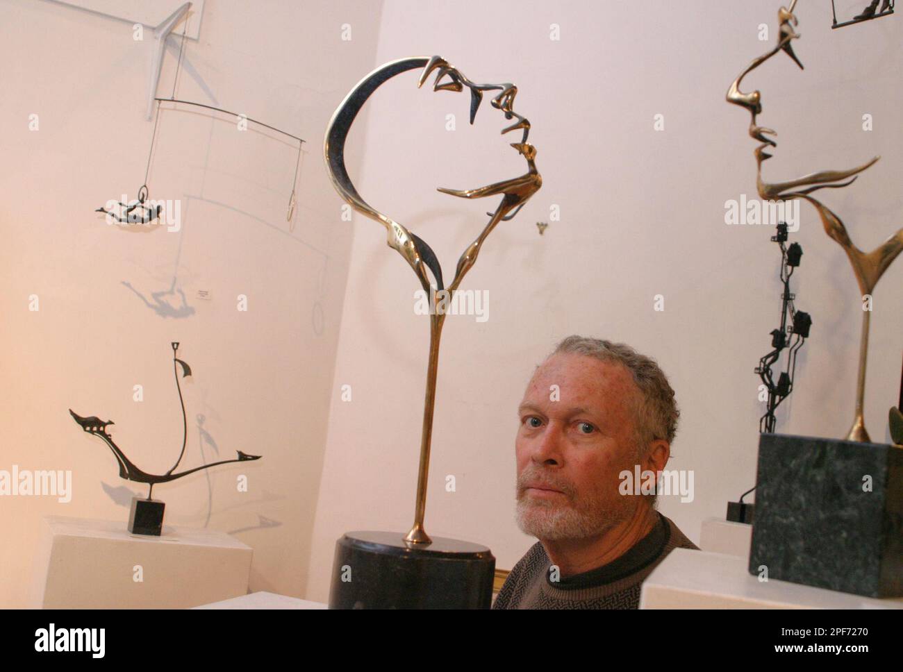 Sculptor Patrick Farrow sits among his bronze sculptures Dreamer, at ...