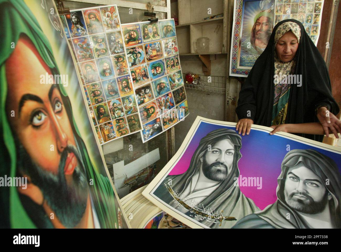An Iraqi woman looks at posters of Shiite saints at Baghdad's book ...