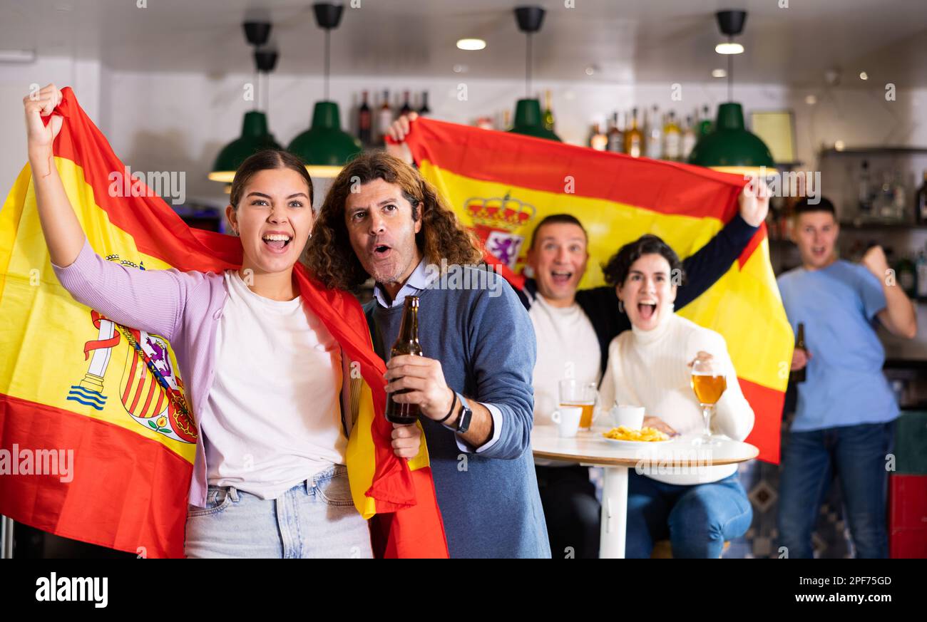 Company of emotive young adult sports fans supporting Spanish football ...