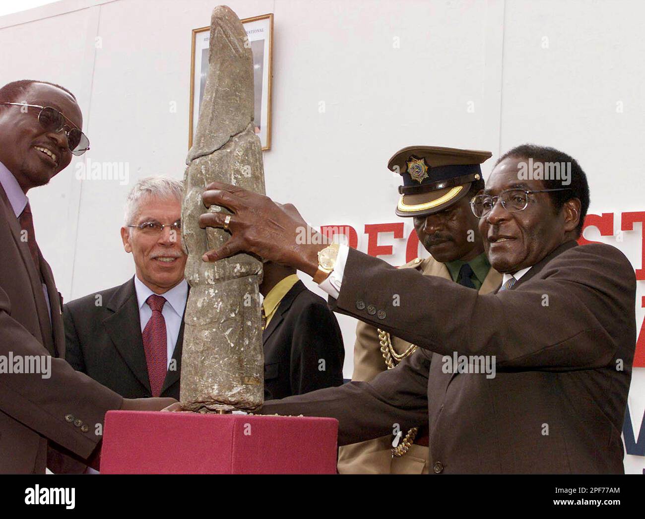 Zimbabwean President Robert Mugabe holds the lower portion of the ...