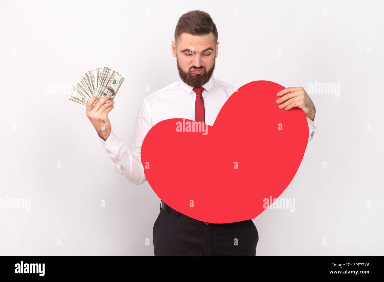 Portrait of young adult bearded man wearing white shirt and tie holding ...