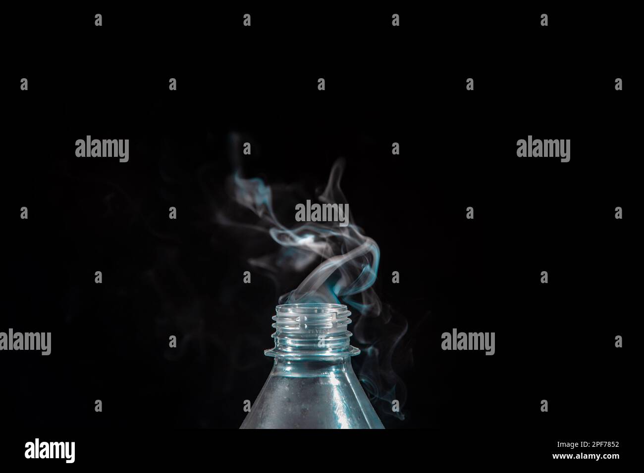 Moving smoke coming out of a plastic bottle. Isolated on black ...