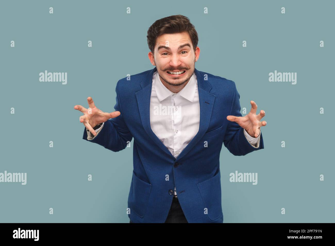 Angry aggressive attractive man standing clenched hid hands, screaming ...