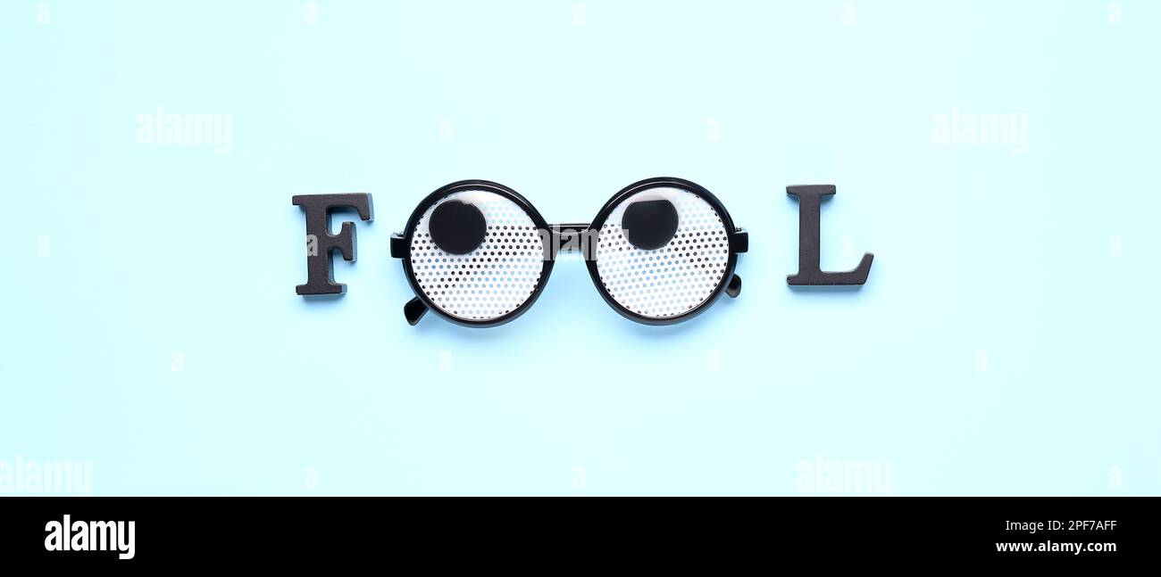 Word FOOL with funny eyeglasses on light blue background Stock Photo ...