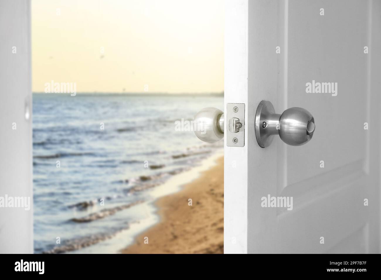 View on sea resort through open door Stock Photo - Alamy