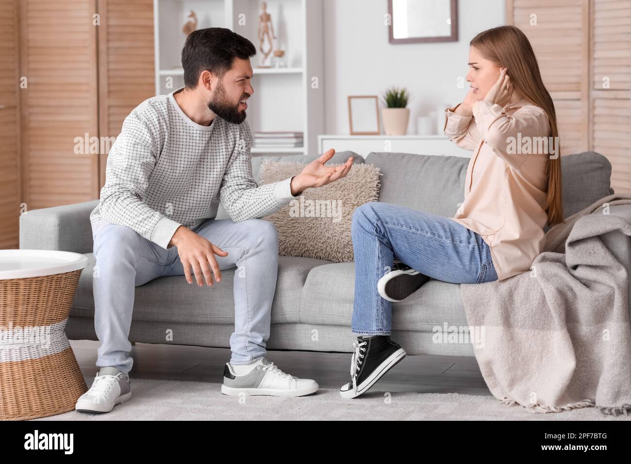 Young man quarreling with his wife at home Stock Photo - Alamy
