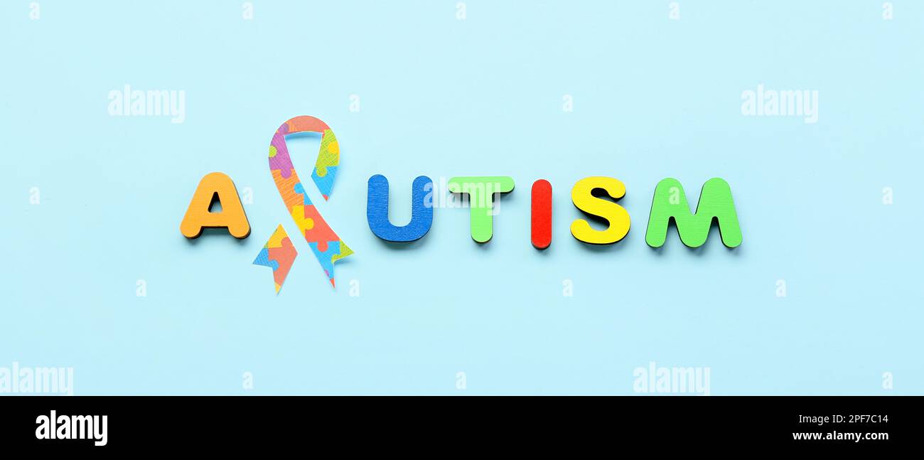 Word AUTISM with paper awareness ribbon on light blue background Stock ...