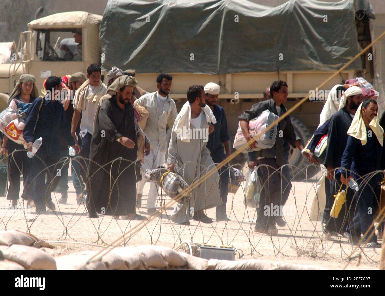 Iraqi prisoners of war) walk toward the gates of Camp Bucca in Umm Qasr ...