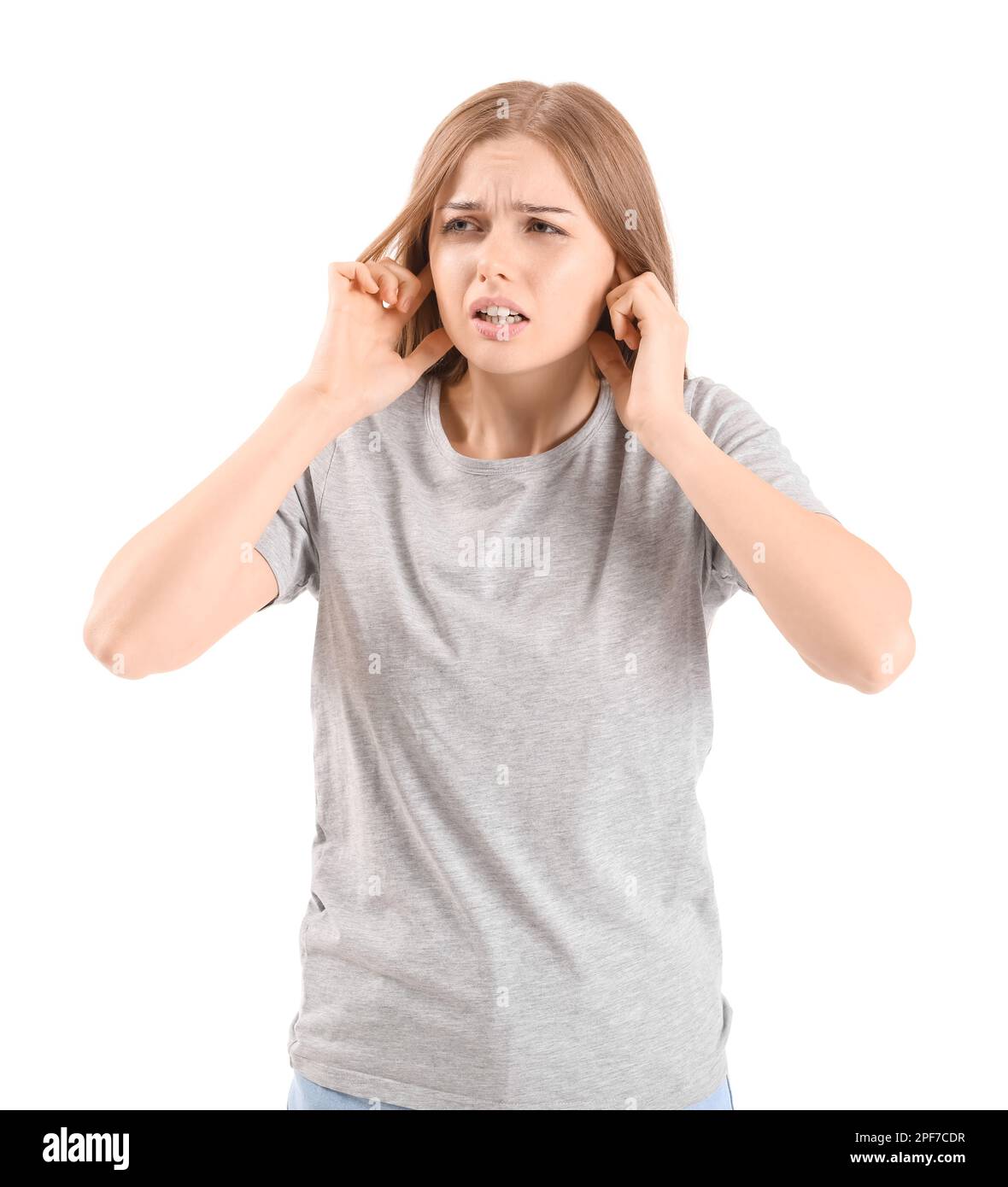 Irritated young woman suffering from loud noise on white background ...