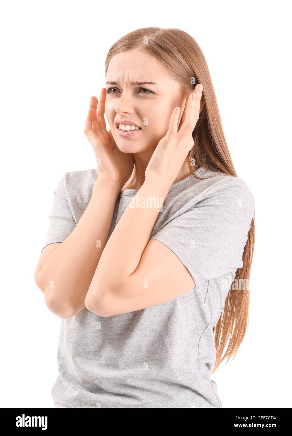 Irritated young woman suffering from loud noise on white background ...