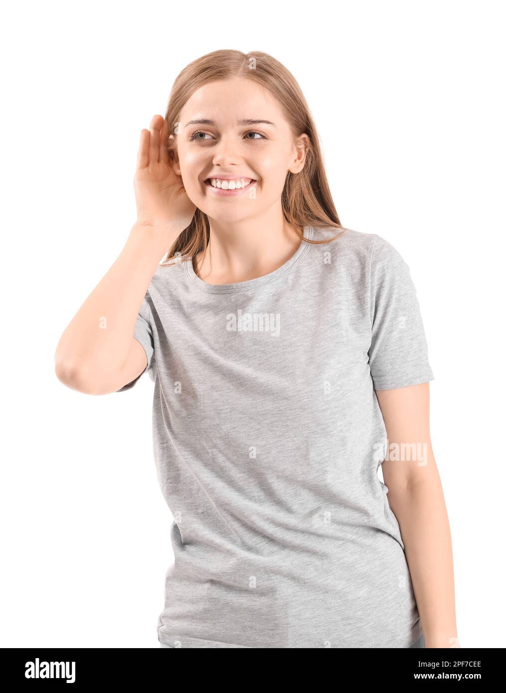 Young woman trying to hear something on white background Stock Photo ...