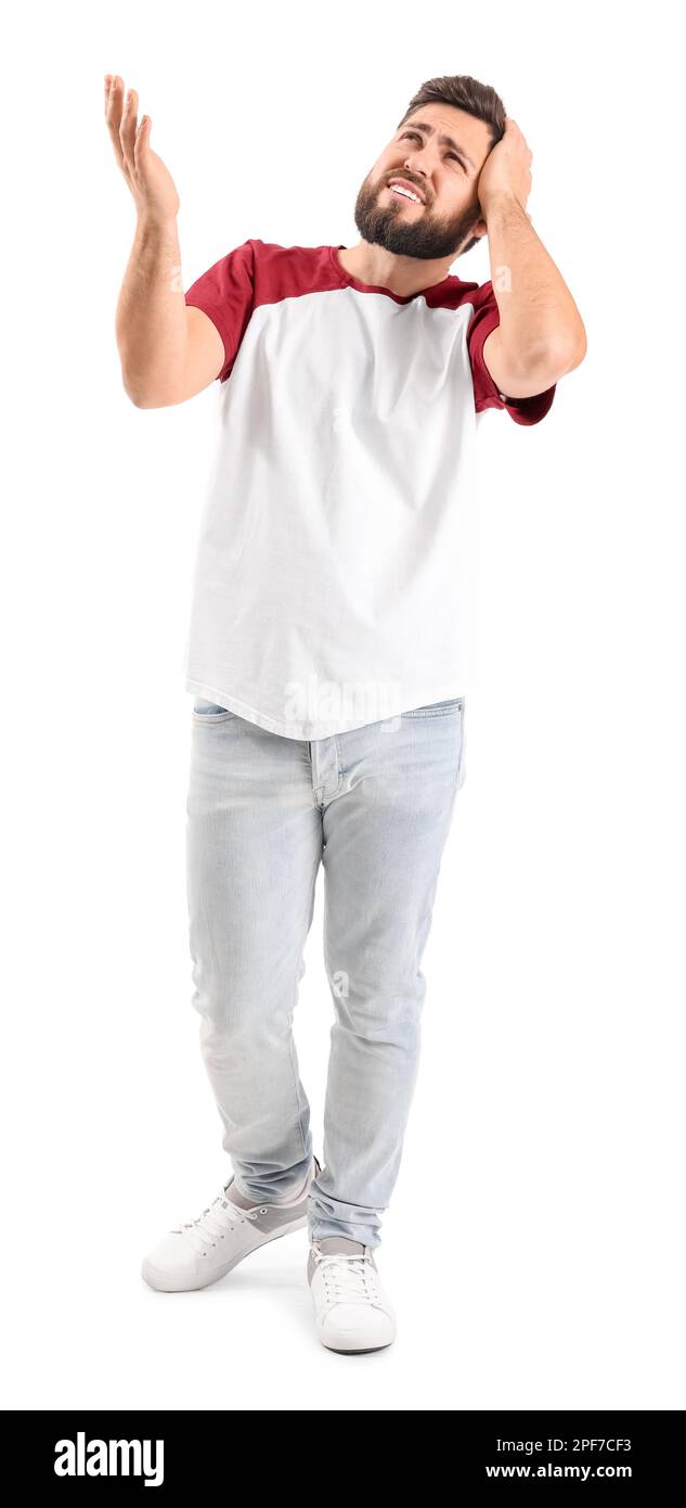 Irritated young man suffering from loud noise on white background Stock ...