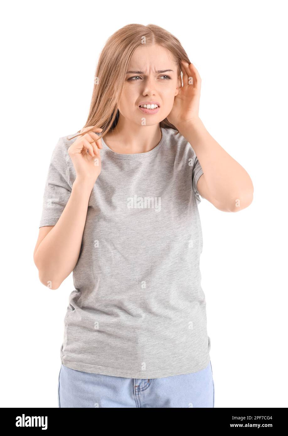 Irritated young woman suffering from loud noise on white background ...