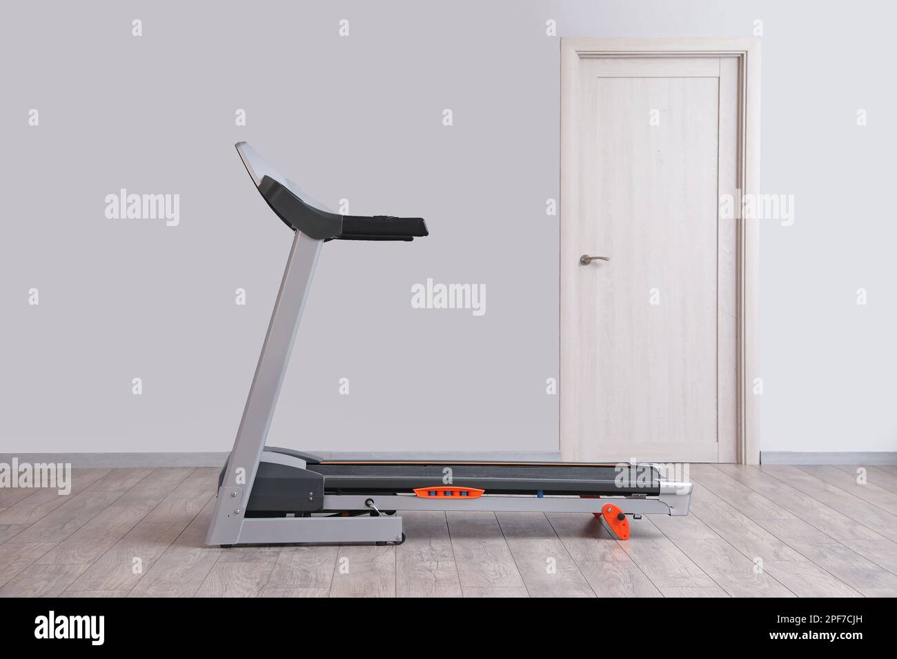 Interior of room with modern treadmill near grey wall Stock Photo - Alamy