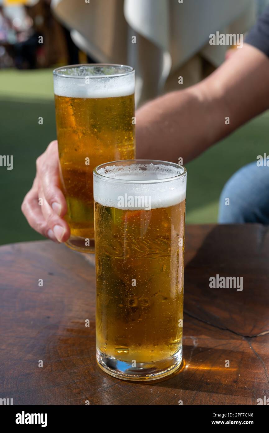 Fresh draught lager or IPA beer is glass served in outdoor cafe close ...