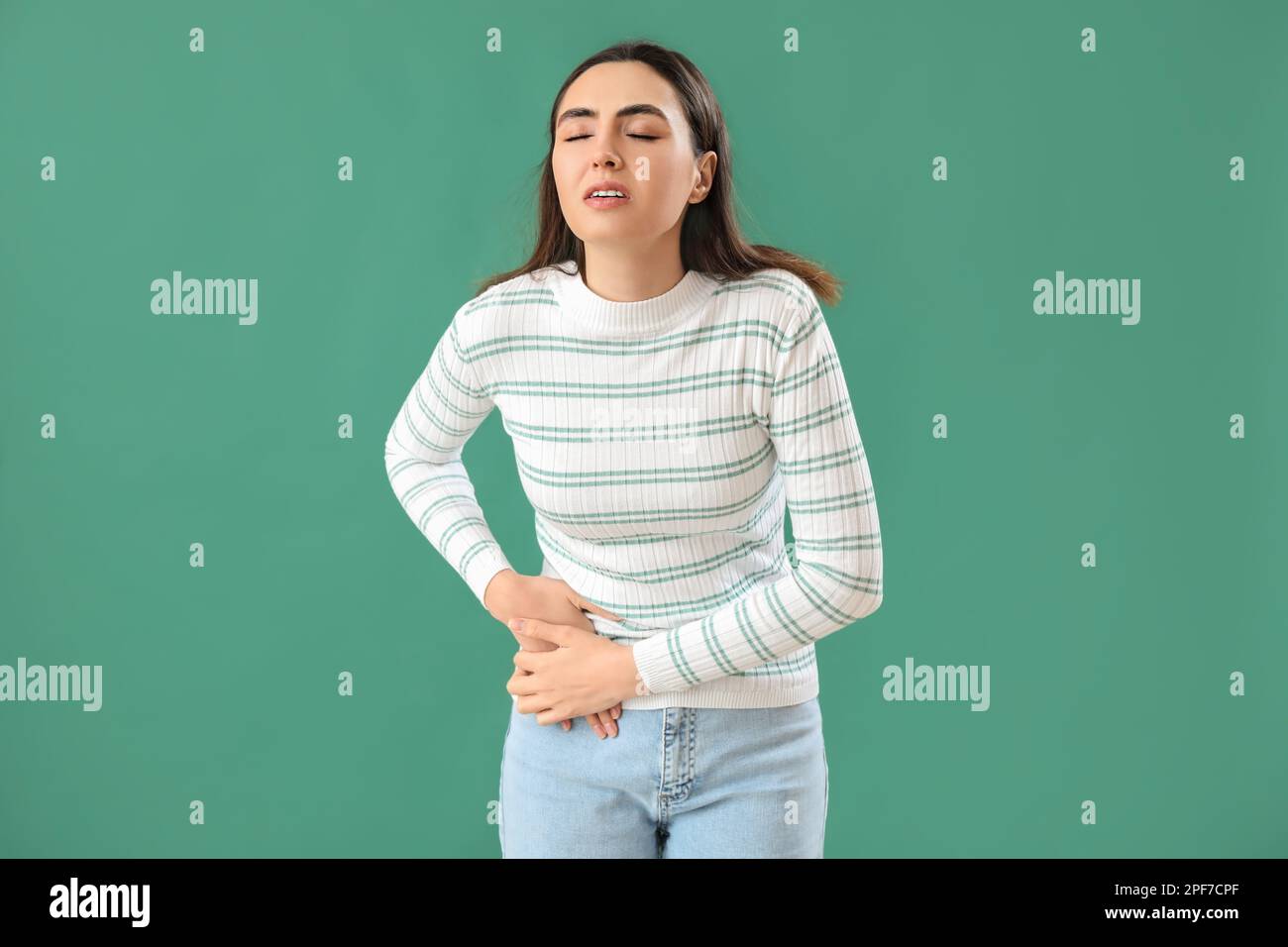 Young woman with appendicitis on green background Stock Photo - Alamy