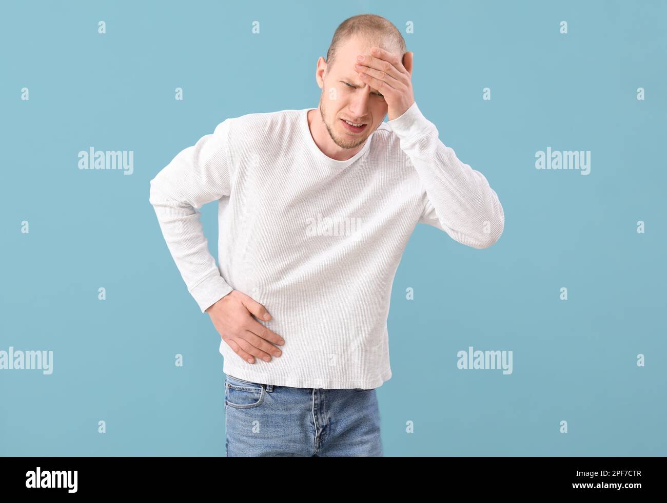 Young man with appendicitis on blue background Stock Photo - Alamy