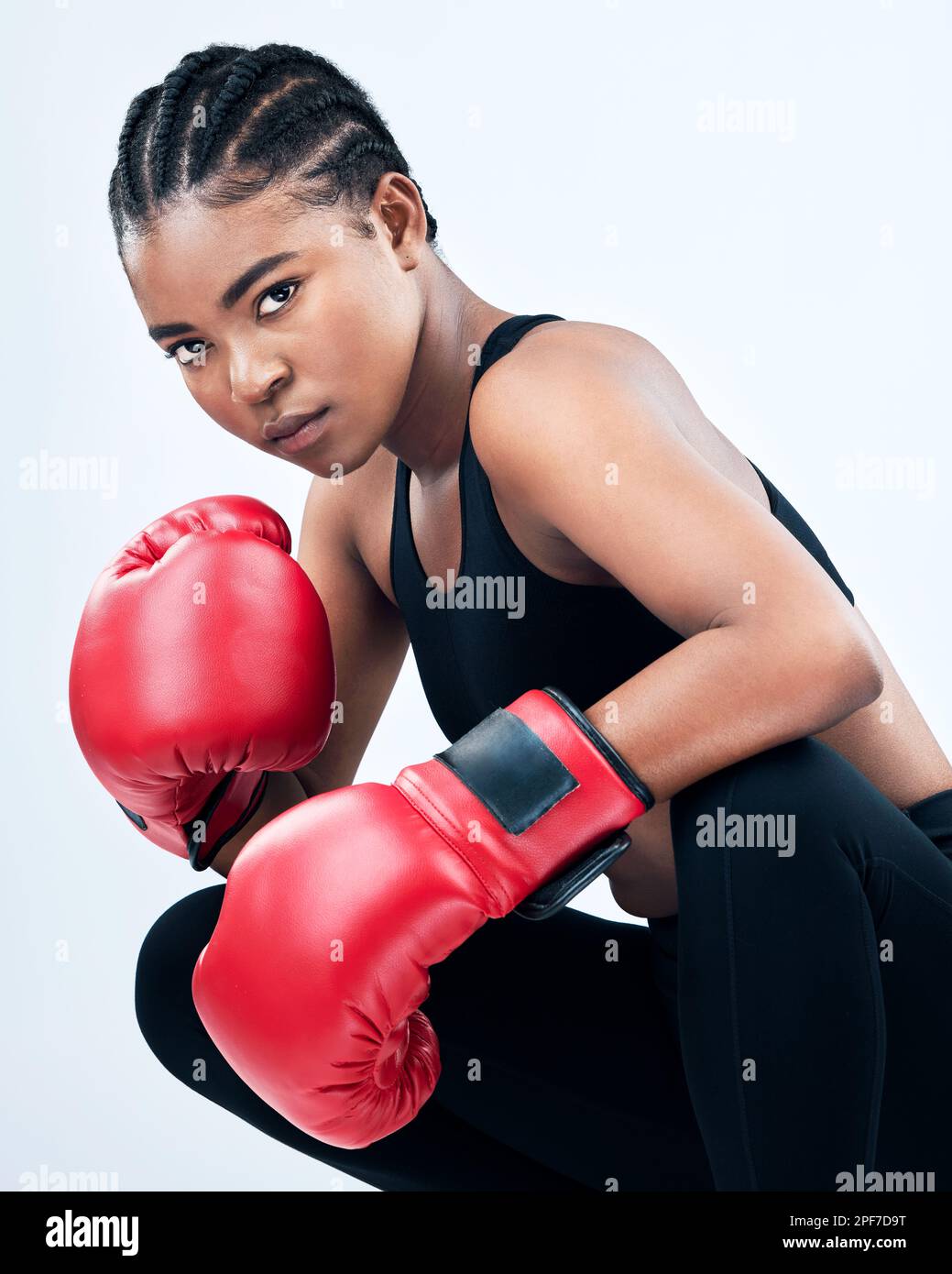 Damn right Im tough. Studio shot of a sporty young woman wearing boxing ...