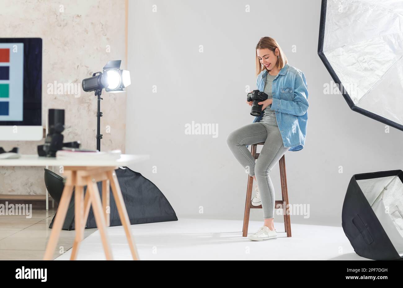 Female photographer with professional camera sitting in studio Stock ...