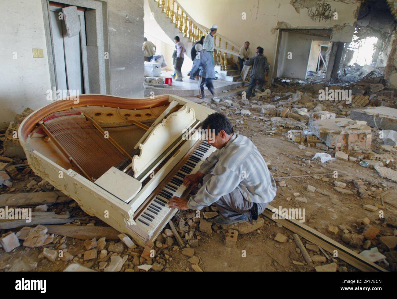 A man plays piano in one of the palaces of ousted Iraq President Saddam ...