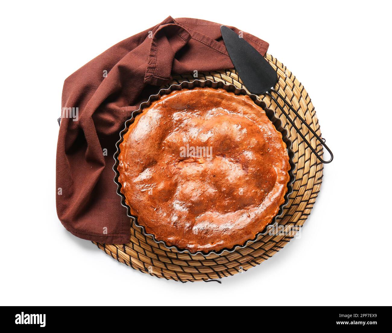 Wicker mat with delicious meat pie in baking form and spatula isolated ...
