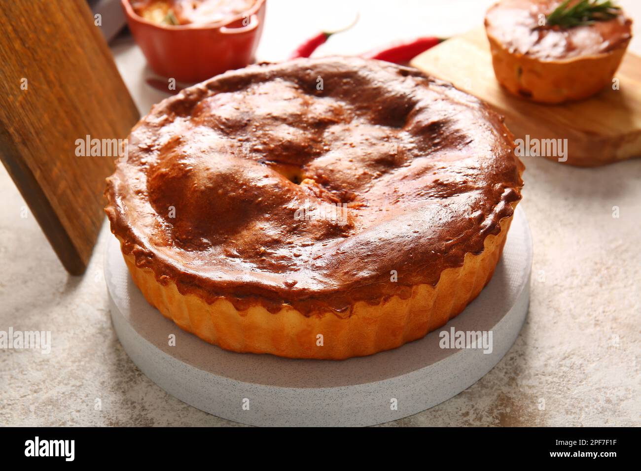 Podium with delicious meat pie on white grunge table Stock Photo - Alamy