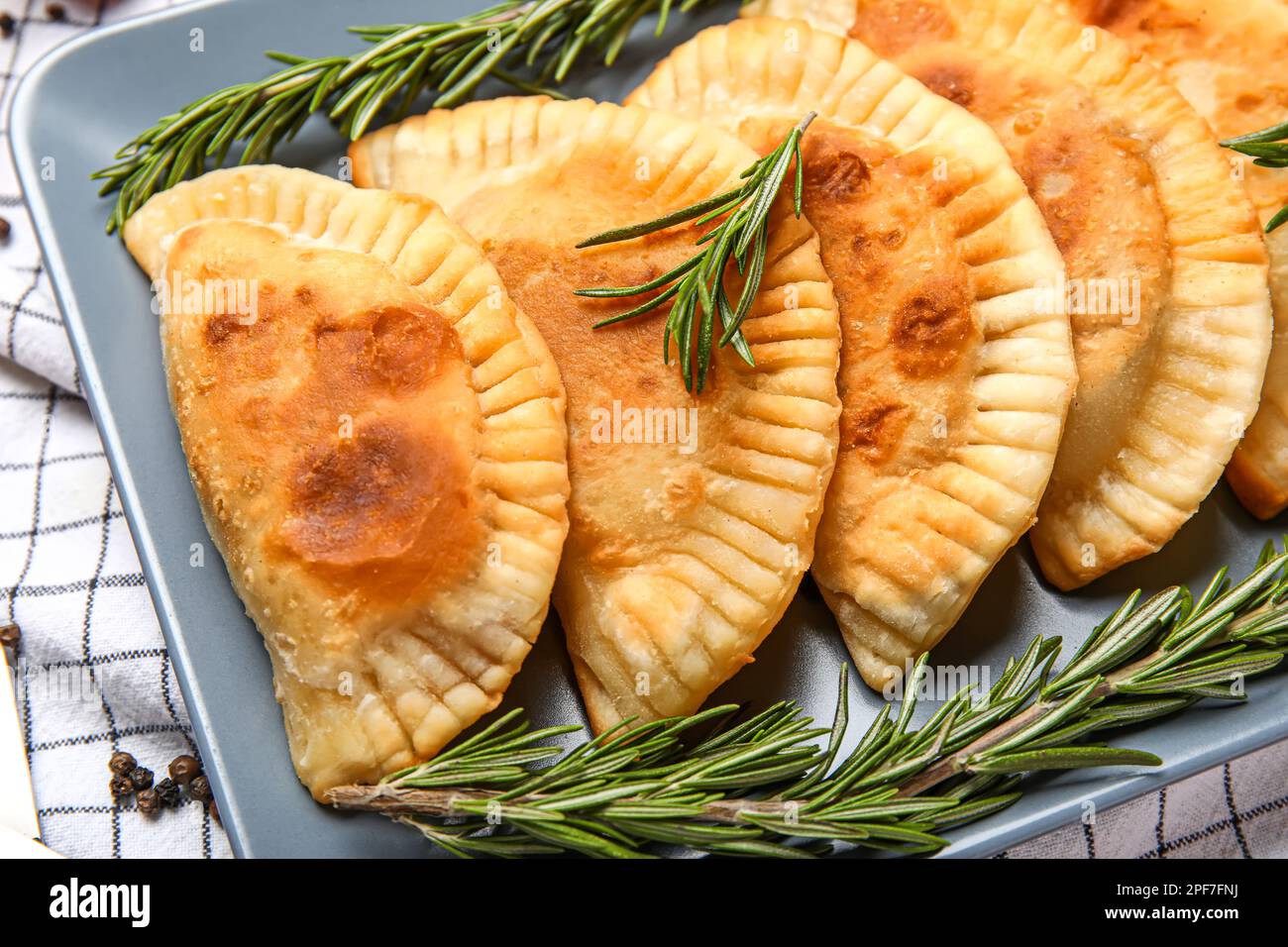 Plate with tasty meat empanadas with rosemary, closeup Stock Photo - Alamy