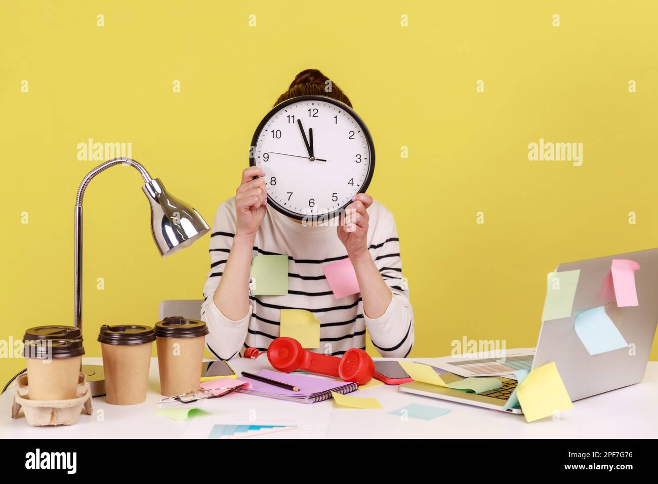 Woman office worker covered with sticky notes sitting at workplace ...