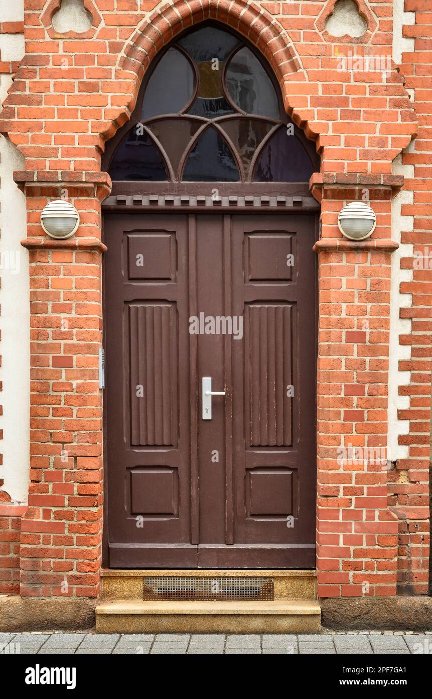View of brick building with wooden door Stock Photo - Alamy