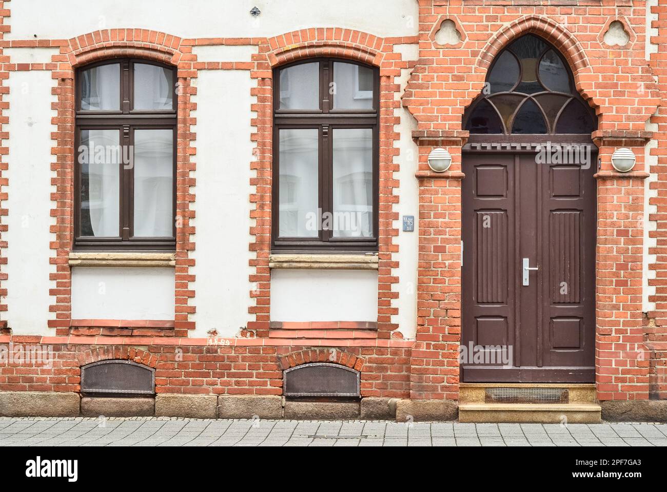 View of brick building with wooden door and windows Stock Photo - Alamy