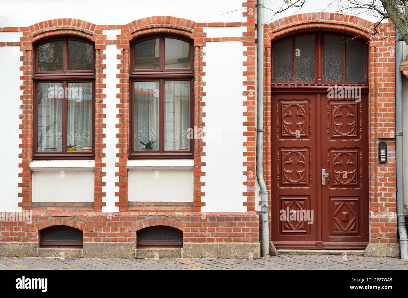 View of brick building with wooden door and windows Stock Photo - Alamy