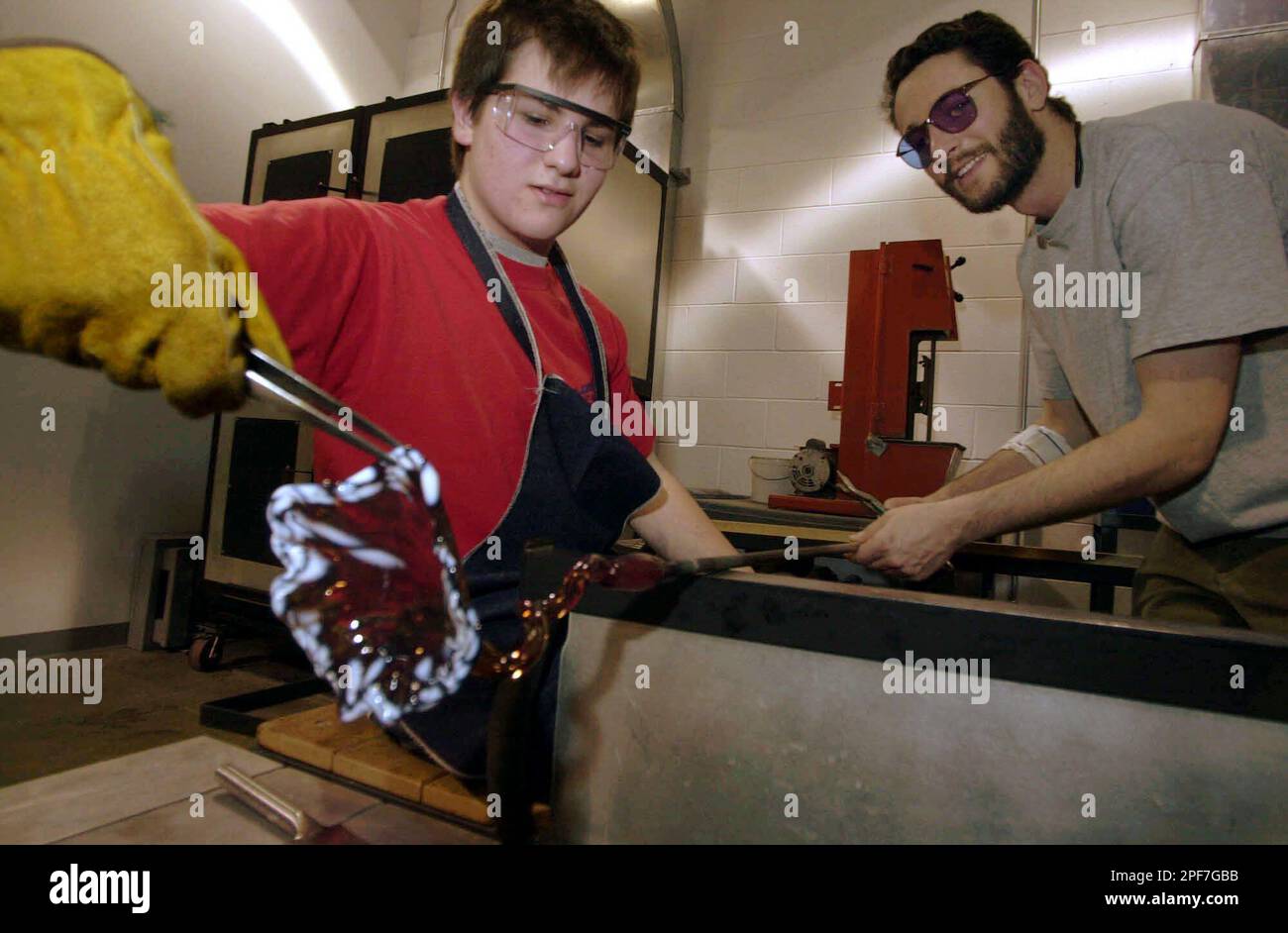 Blaine Strickland, left, of Cincinnati, Ohio, makes a glass flower with ...