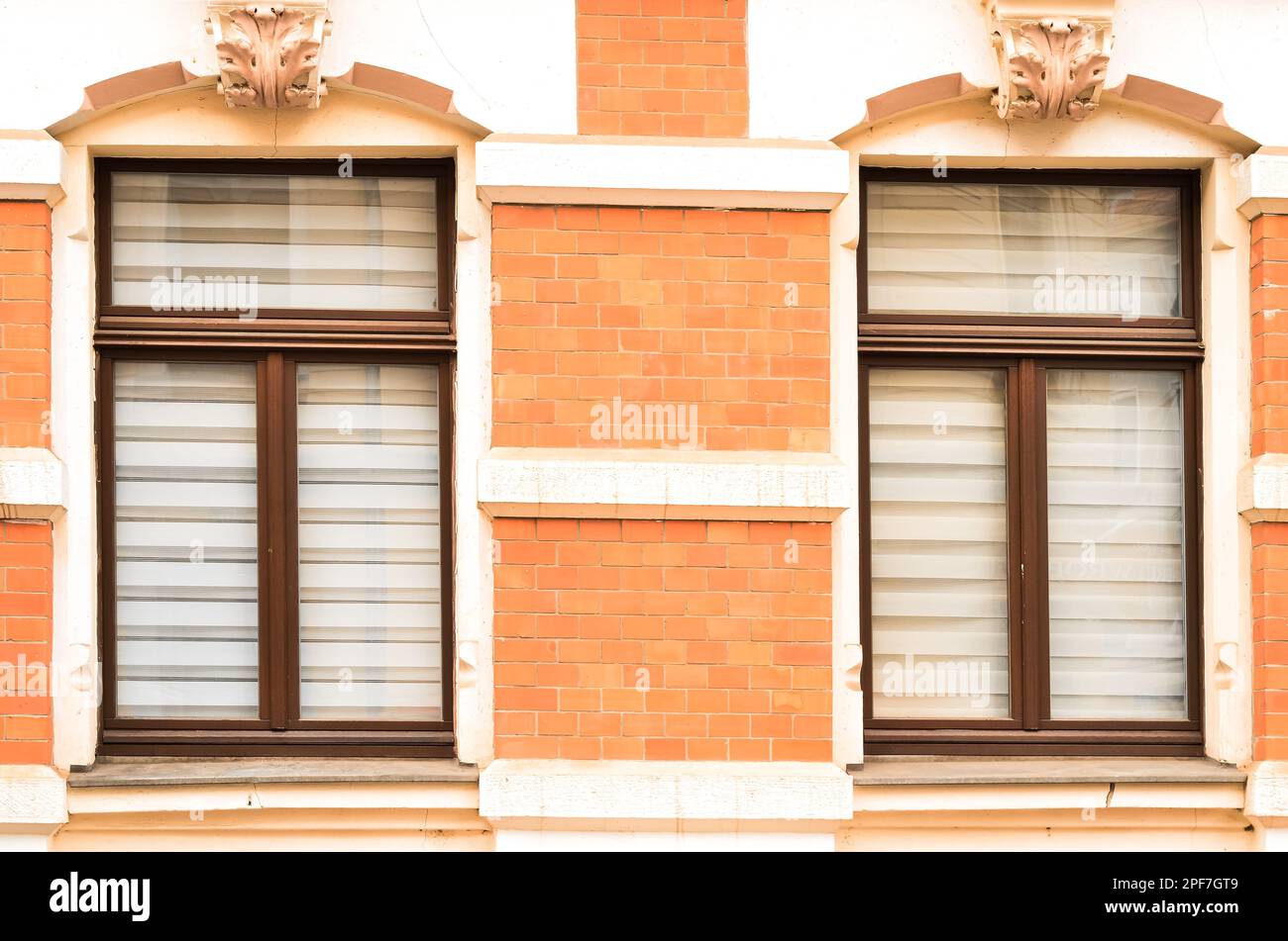 View of brick building with wooden windows Stock Photo - Alamy