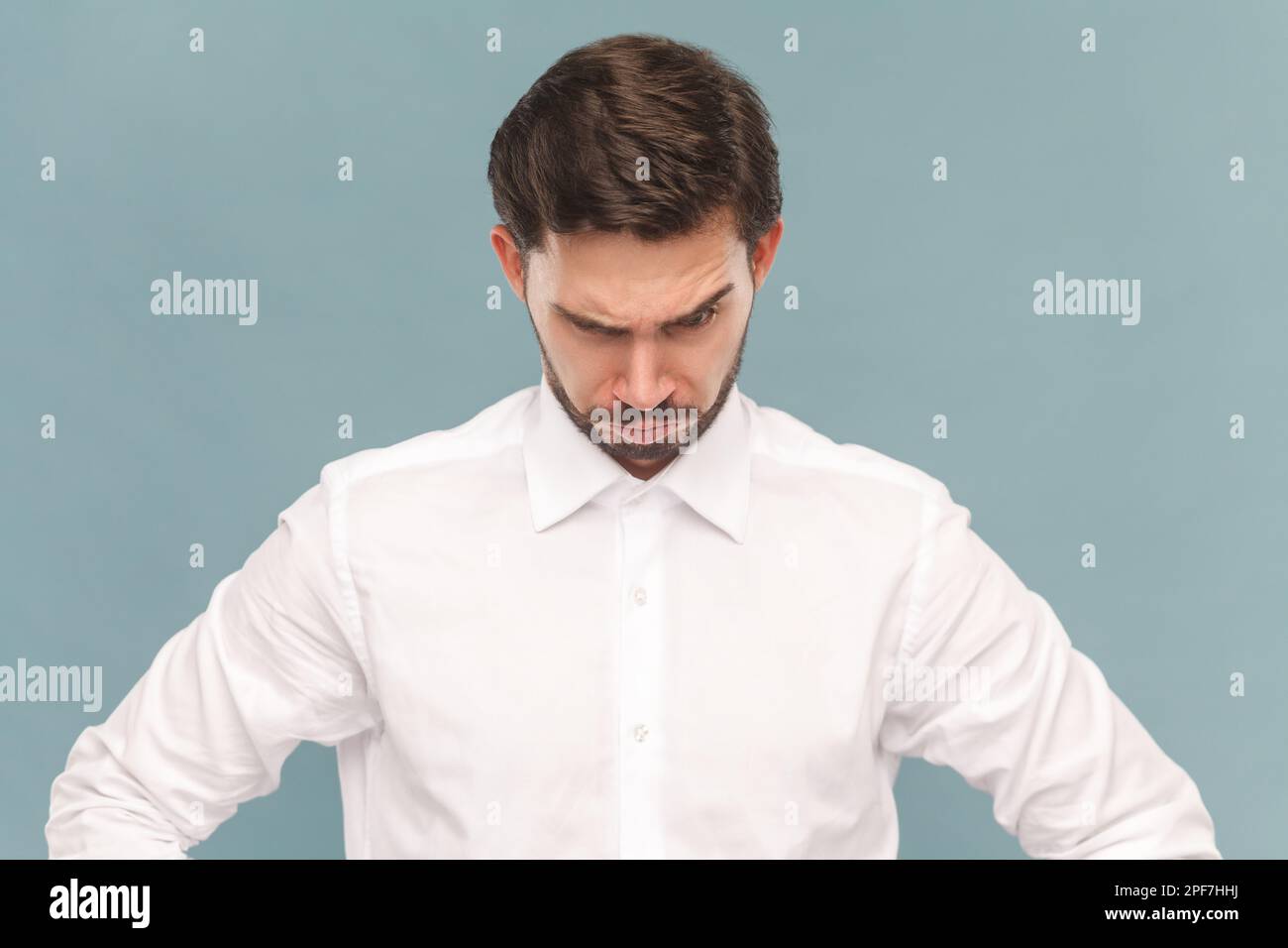 Portrait of pensive strict bully man with mustache with hands on hips ...